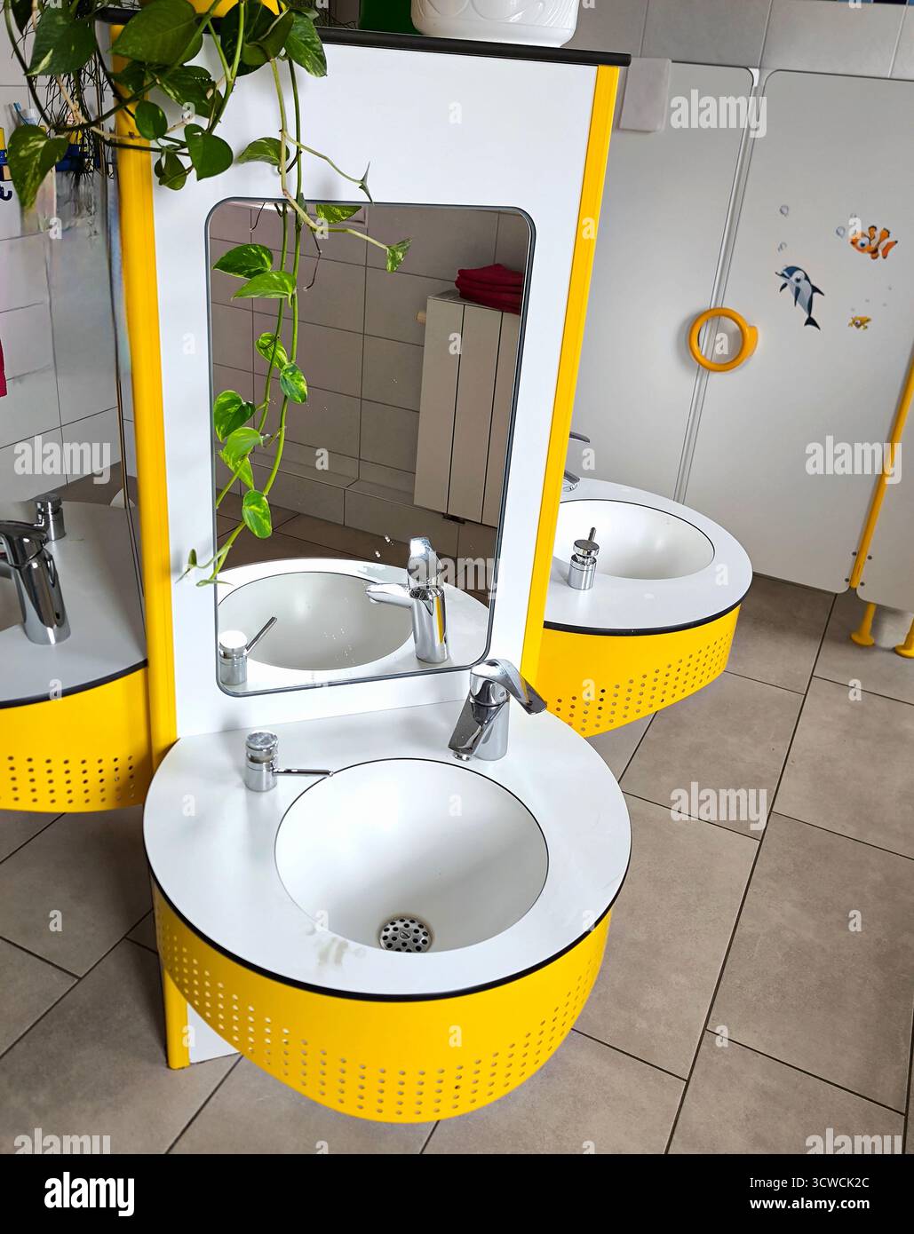 yellow and white children's washbasins in the bathroom of a ...