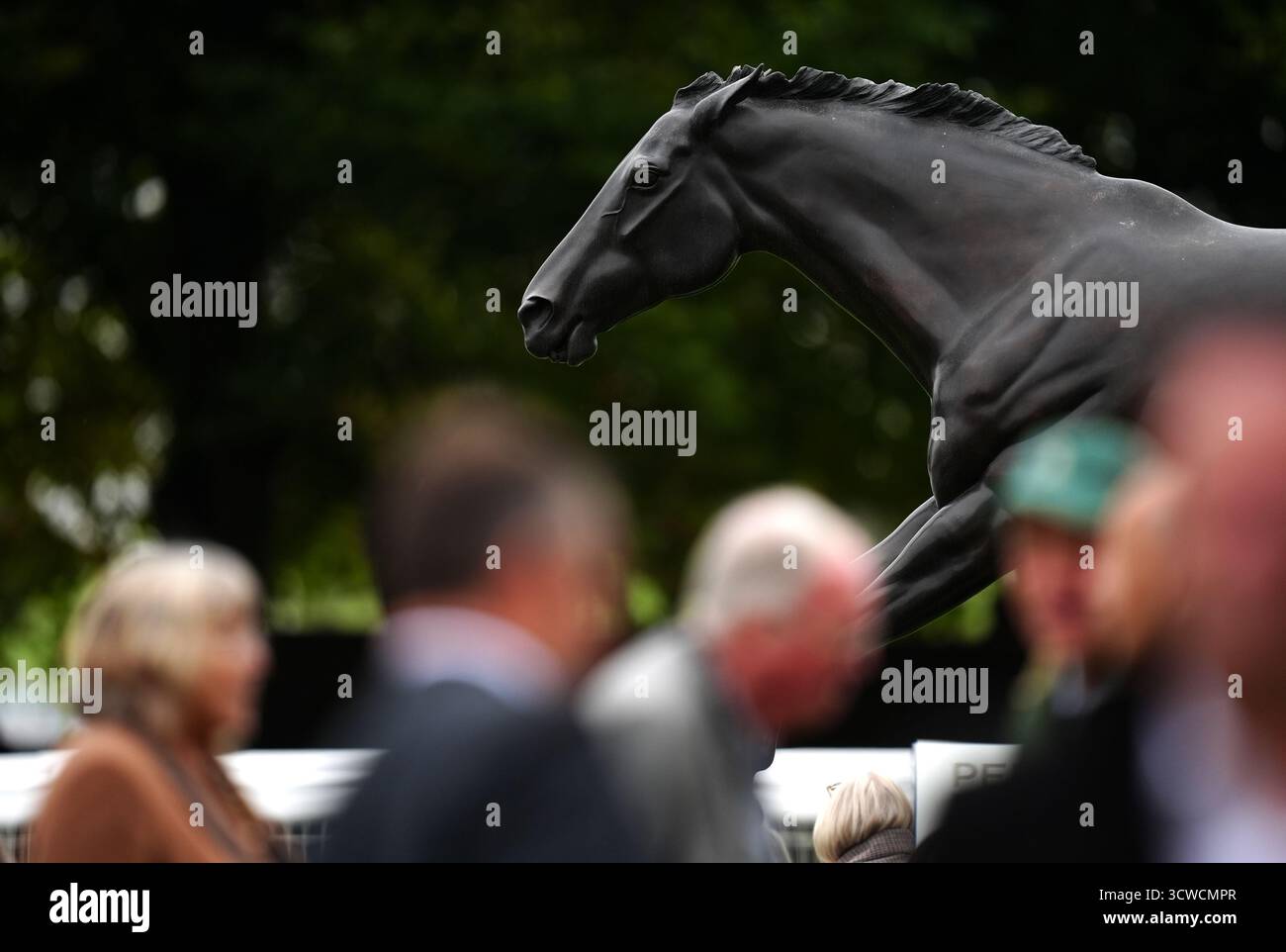 Racegoers walk past the statue of Persian Punch during the Dubai Future ...