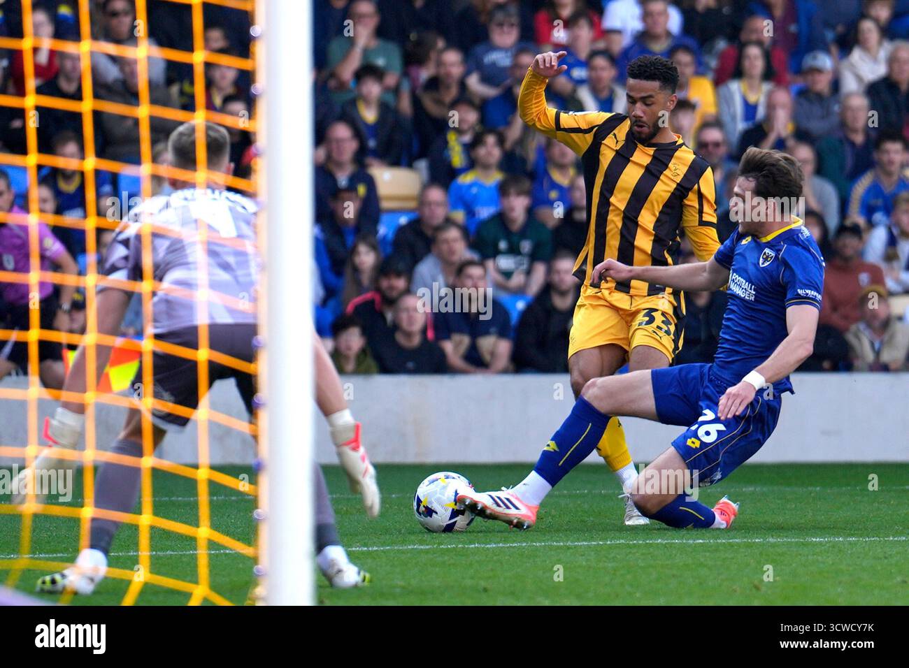 AFC Wimbledon's Riley Harbottle (left) and Port Vale's George Hall battle for the ball during ...