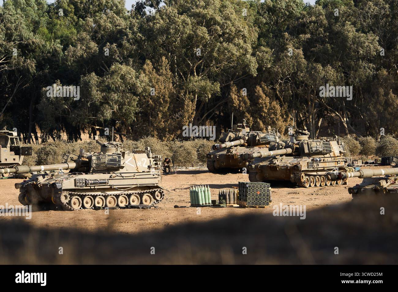 An Israeli soldier rests by a mobile artillery unit at a gathering ...