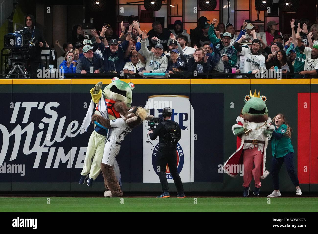 "Humpy," left, is hugged by the Mariner Moose after winning the Salmon ...