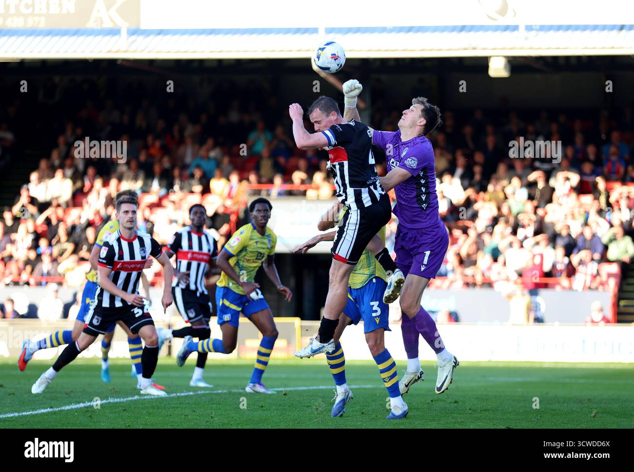 Colchester United goalkeeper Matt Macey (right) punches clear from ...