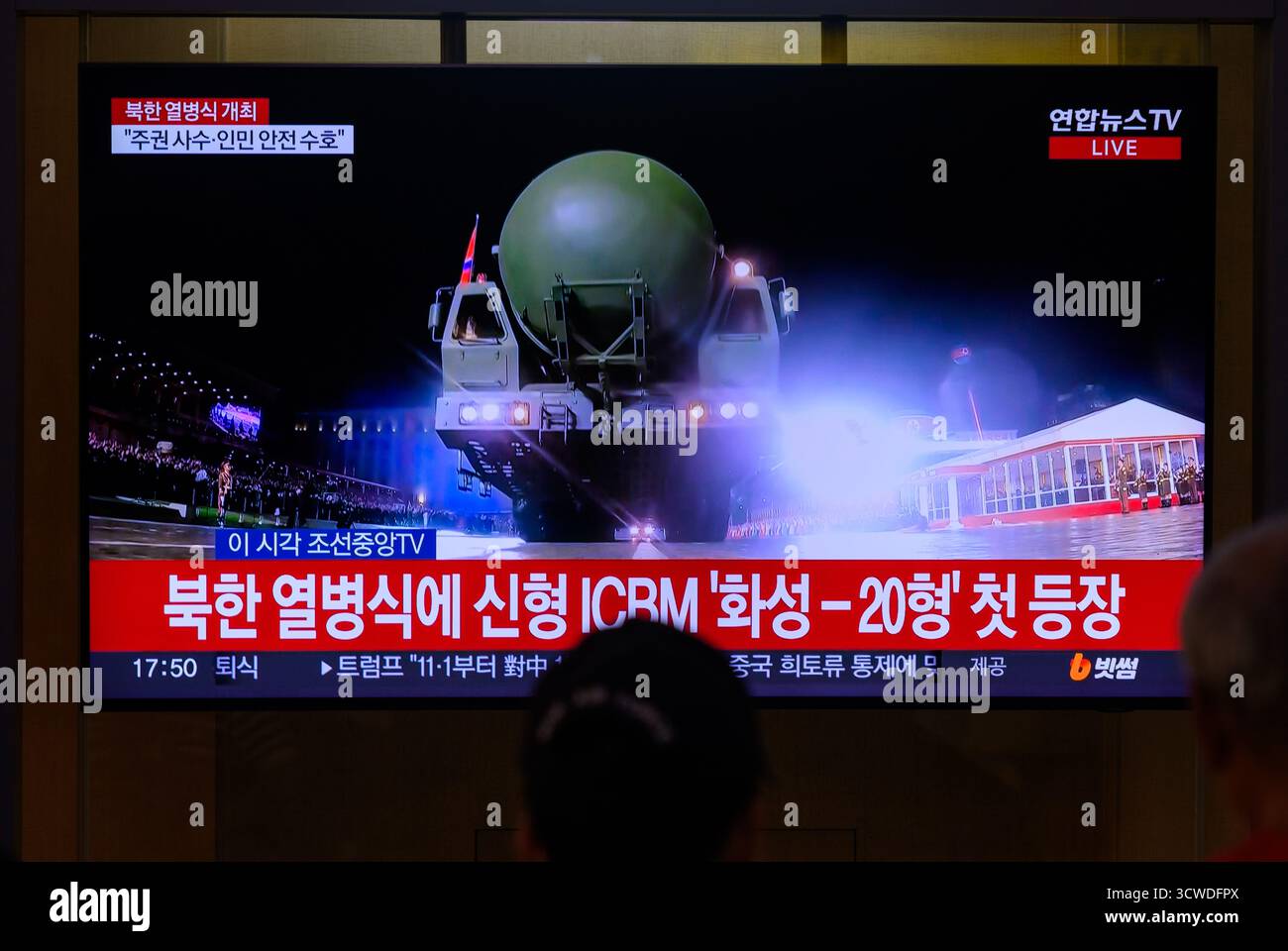 People look at a 24-hour Yonhap news TV broadcast at Seoul Railway ...