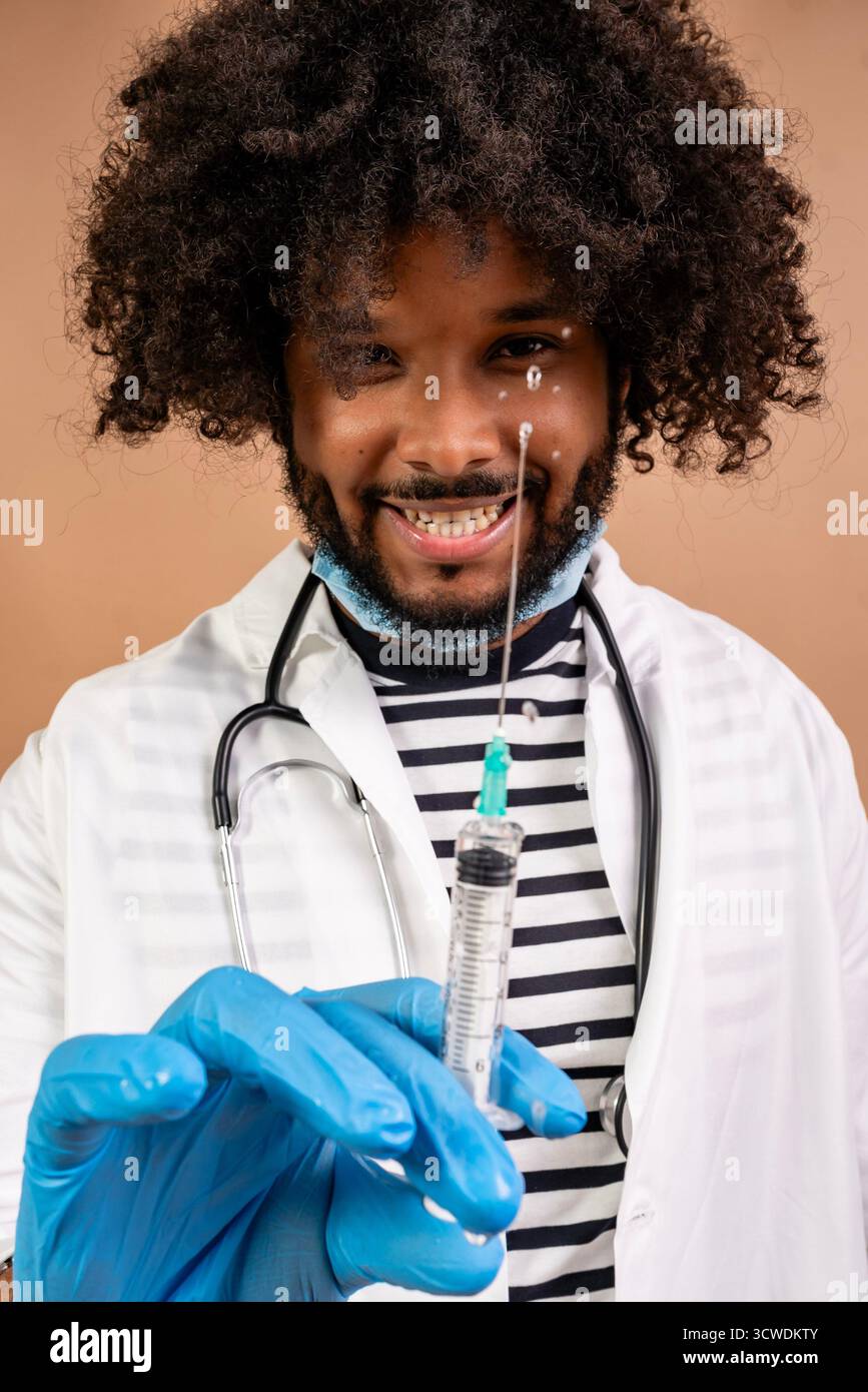Professional doctor wearing lab coat and medical gloves holding syringe ...
