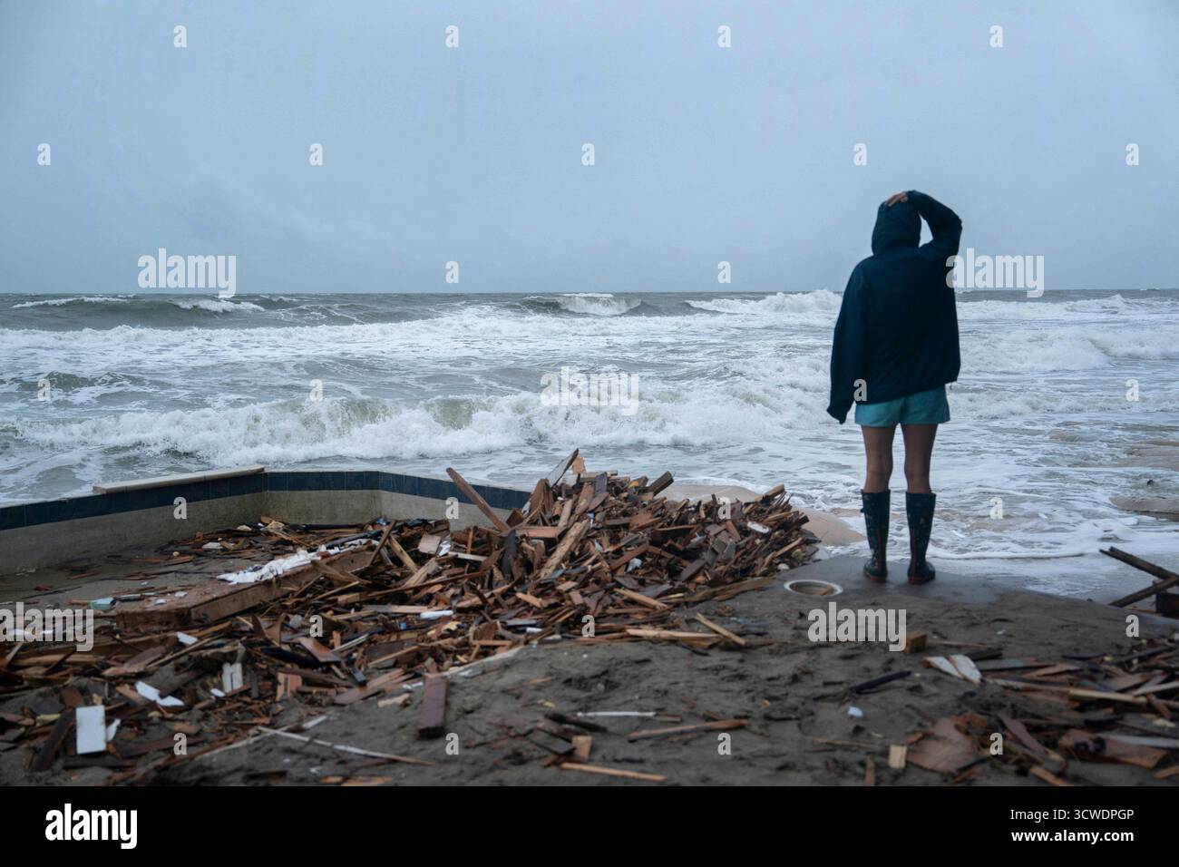 A woman looks out to the ocean as a storm approaches, Saturday, Oct. 12 ...
