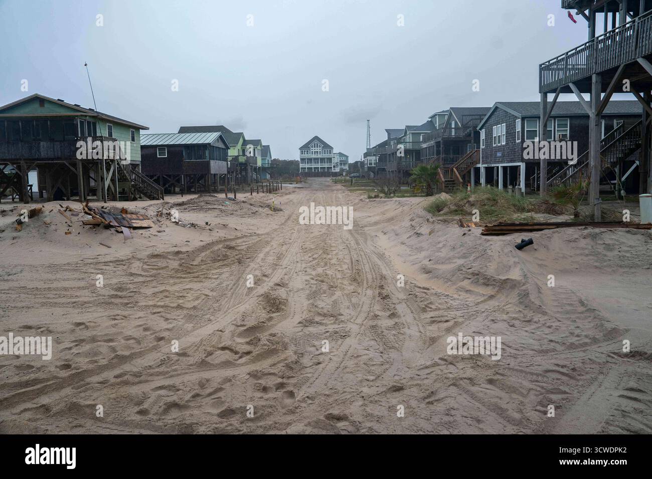 A street is covered in sand as a storm approaches, Saturday, Oct. 11 ...