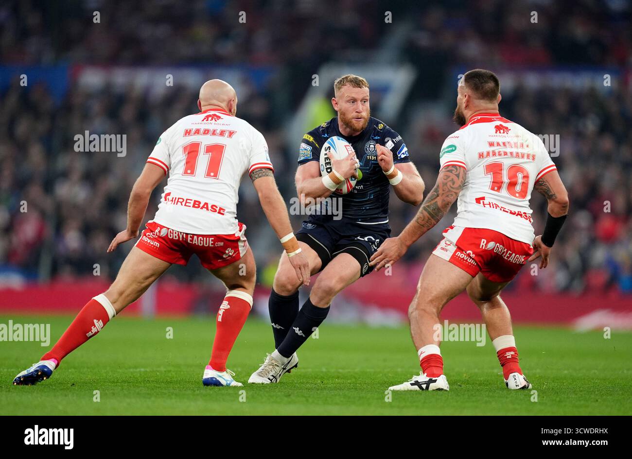 Wigan Warriors' Luke Thompson (centre) runs into Hull KR's Dean Hadley ...