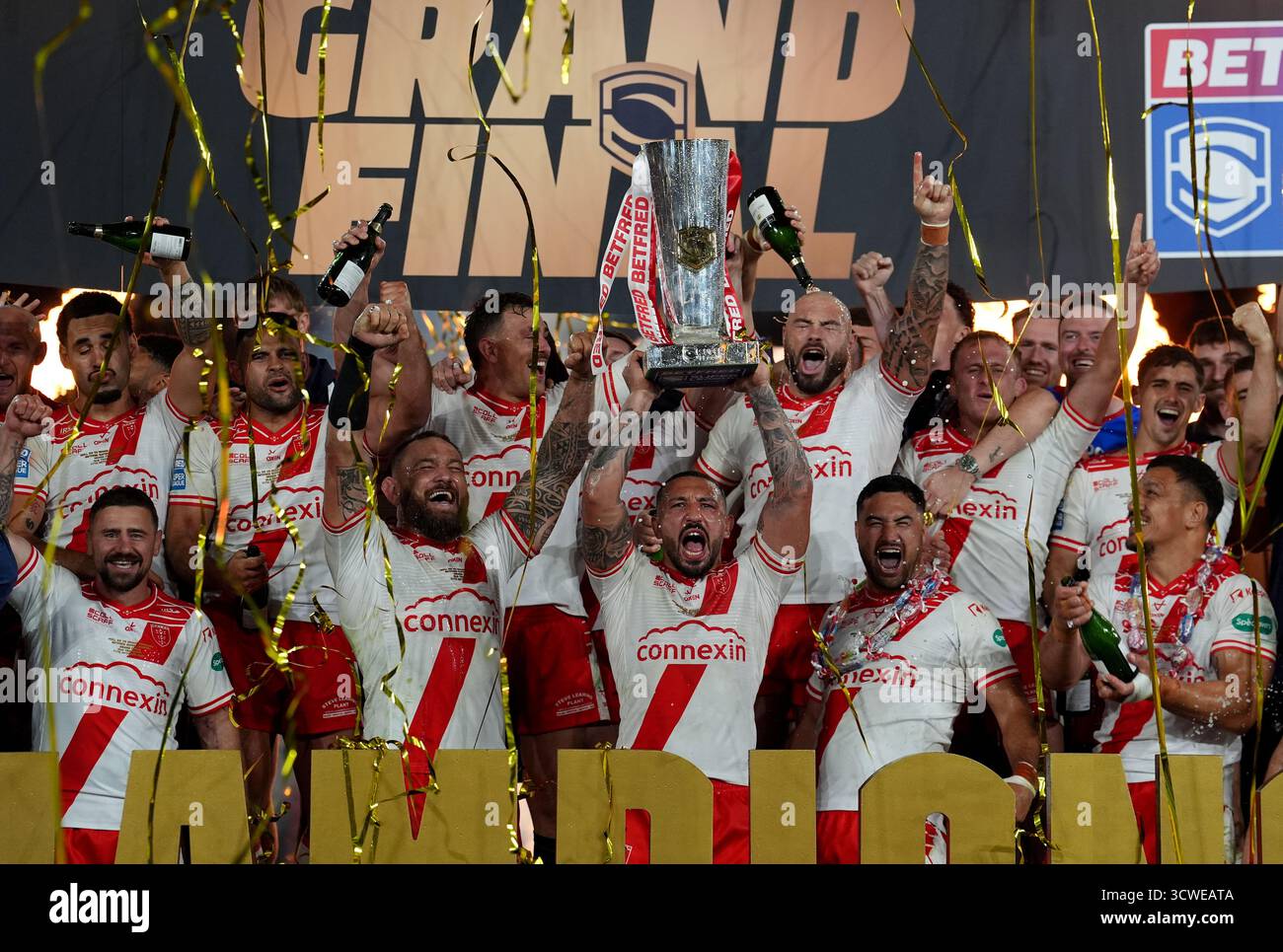 Hull KR's Elliot Minchella (centre) lifts the trophy as his team ...