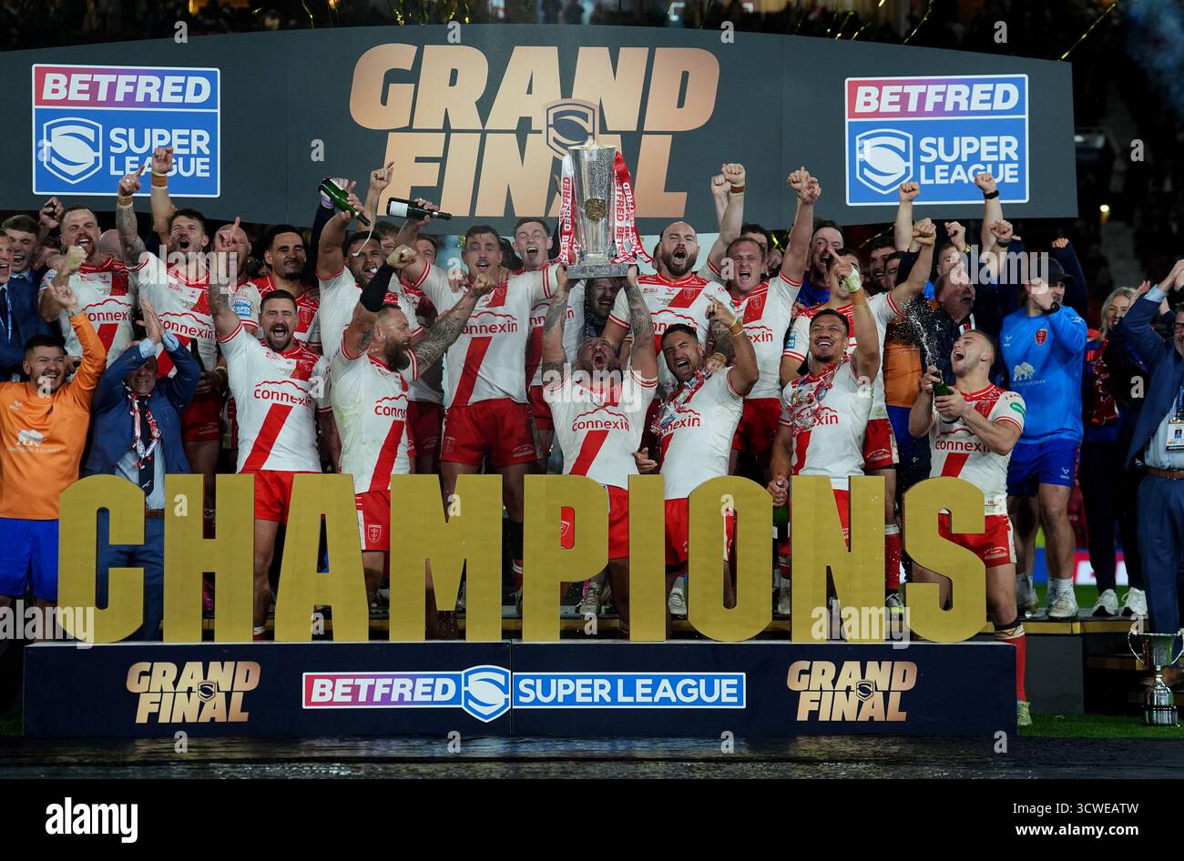 Hull KR's Elliot Minchella (centre) lifts the trophy as his team ...