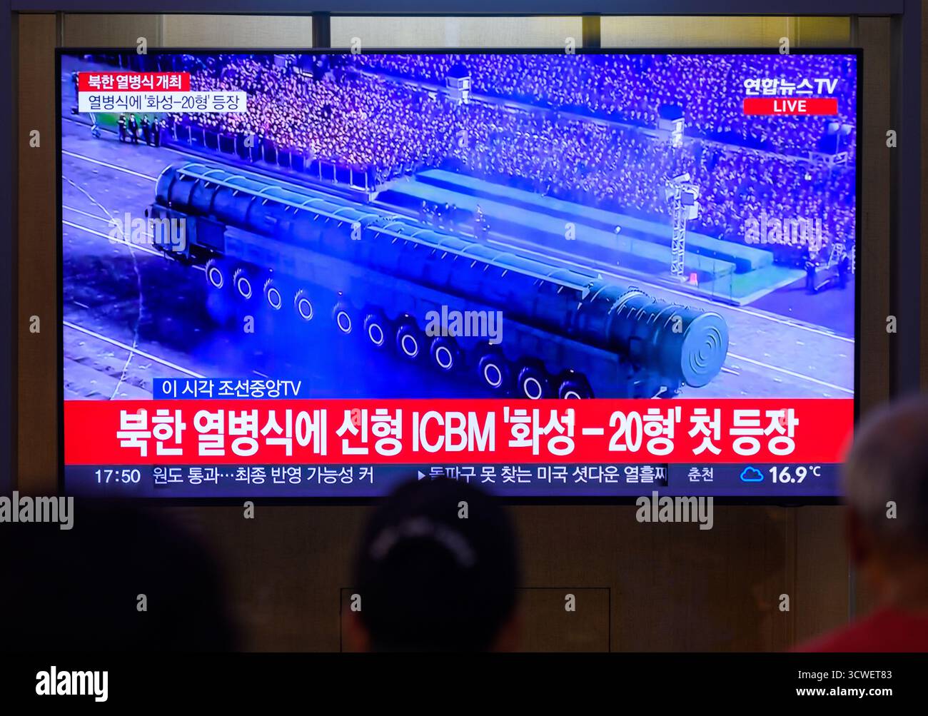 People look at a 24-hour Yonhap news TV broadcast at Seoul Railway ...