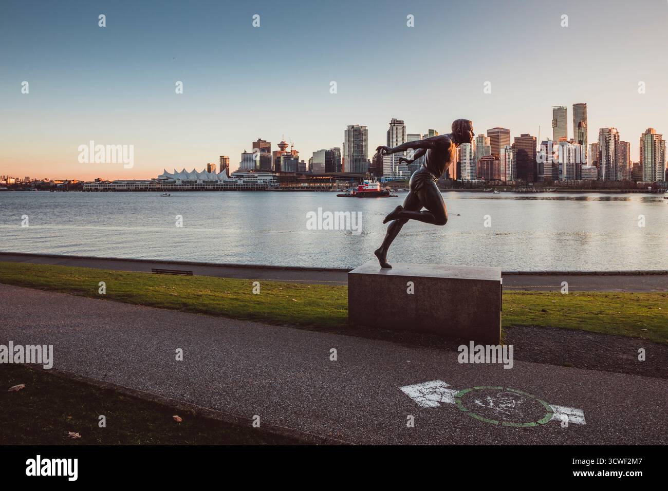 A bronze statue of a runner captures motion against a stunning city ...
