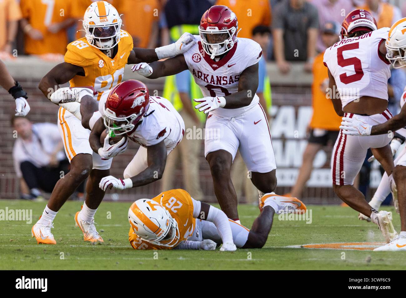 Arkansas running back Mike Washington (4) goes airborne as he's tripped ...