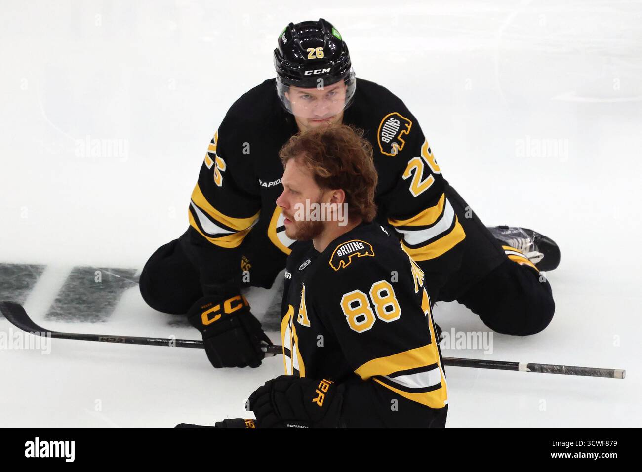 Boston Bruins' Andrew Peeke (26) and David Pastrnak (88) warm up before ...