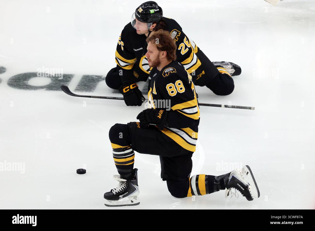 Boston Bruins' Andrew Peeke (26) and David Pastrnak (88) warm up before ...