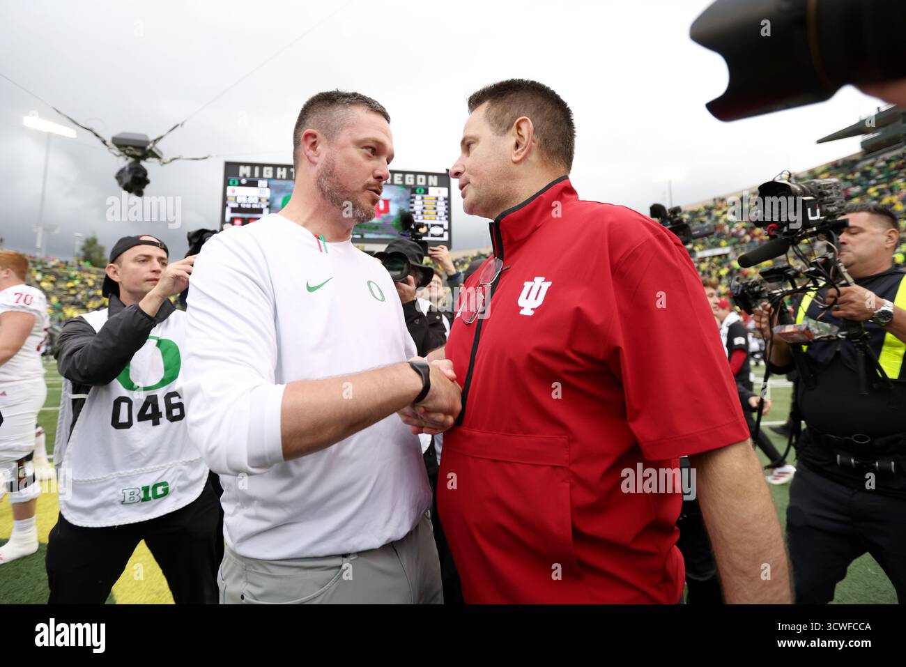 Oregon head coach Dan Lanning, left, and Indiana head coach Curt ...