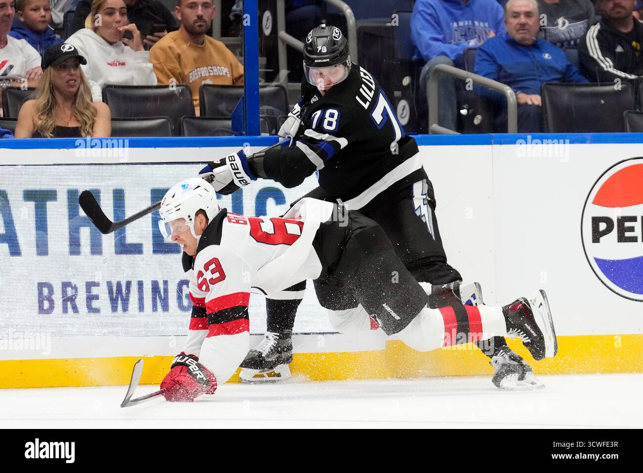 Tampa Bay Lightning defenseman Emil Lilleberg (78) knocks down New Jersey Devils left wing ...