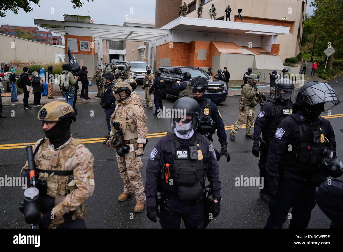 Law enforcement stand in the street to allow vehicles to leave a U.S ...