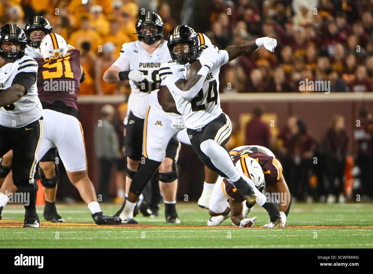 Purdue running back Malachi Thomas (24) runs past Minnesota defenders ...