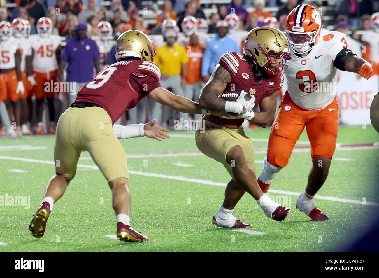 Boston College quarterback Dylan Lonergan, left, hands off the ball to ...