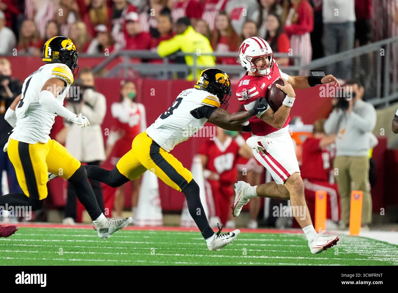 Wisconsin quarterback Hunter Simmons, right, scrambles against Iowa ...