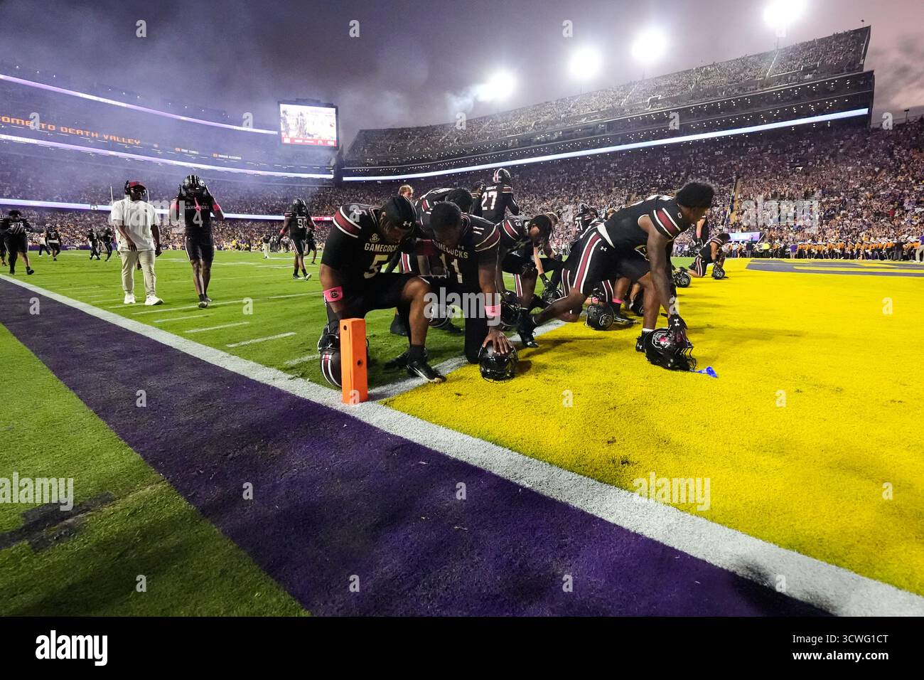 South Carolina players kneel in the end zone in prayer before an NCAA ...