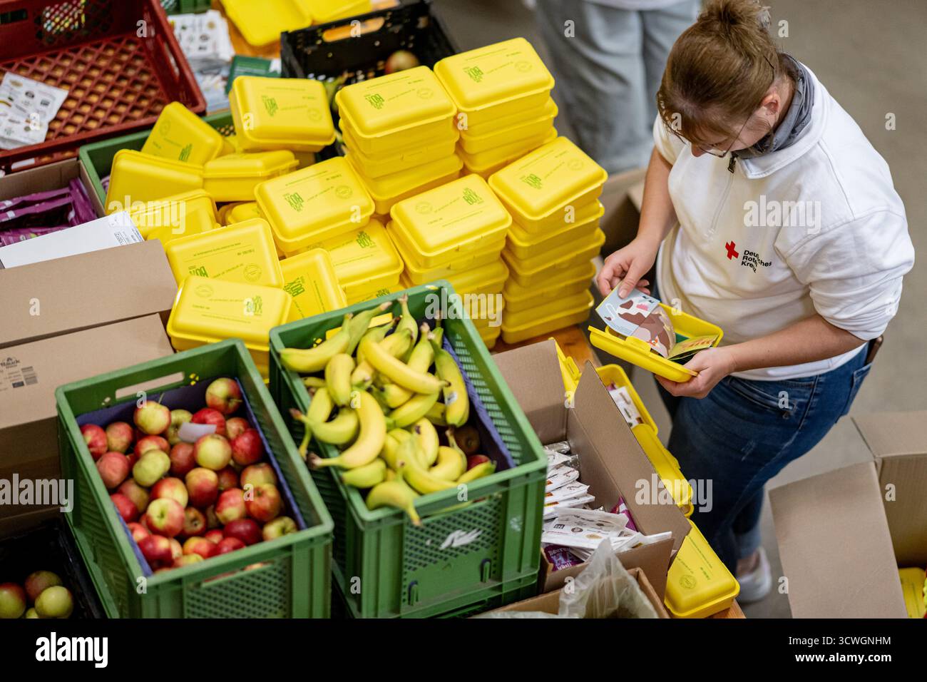 12 October 2025, Berlin: Volunteers from the German Red Cross pack lunch boxes for ...