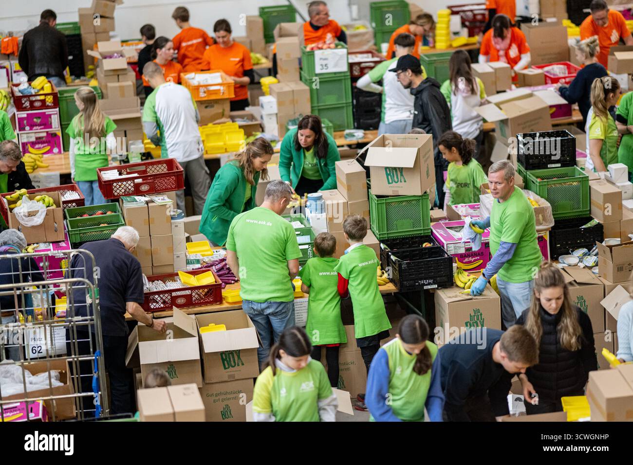 12 October 2025, Berlin: people pack lunch boxes for schoolchildren as ...