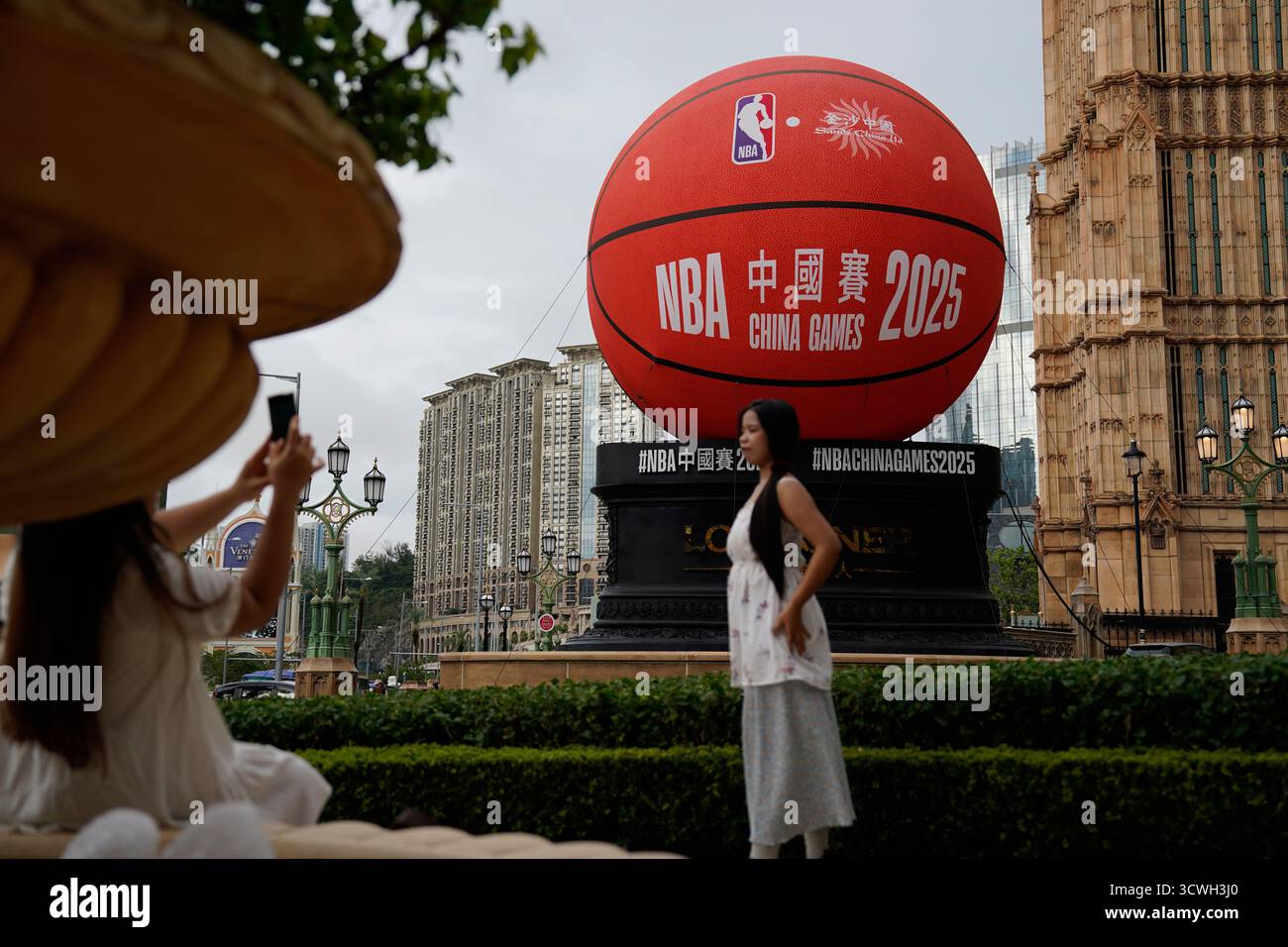 A woman takes a photo before a preseason NBA basketball game between ...