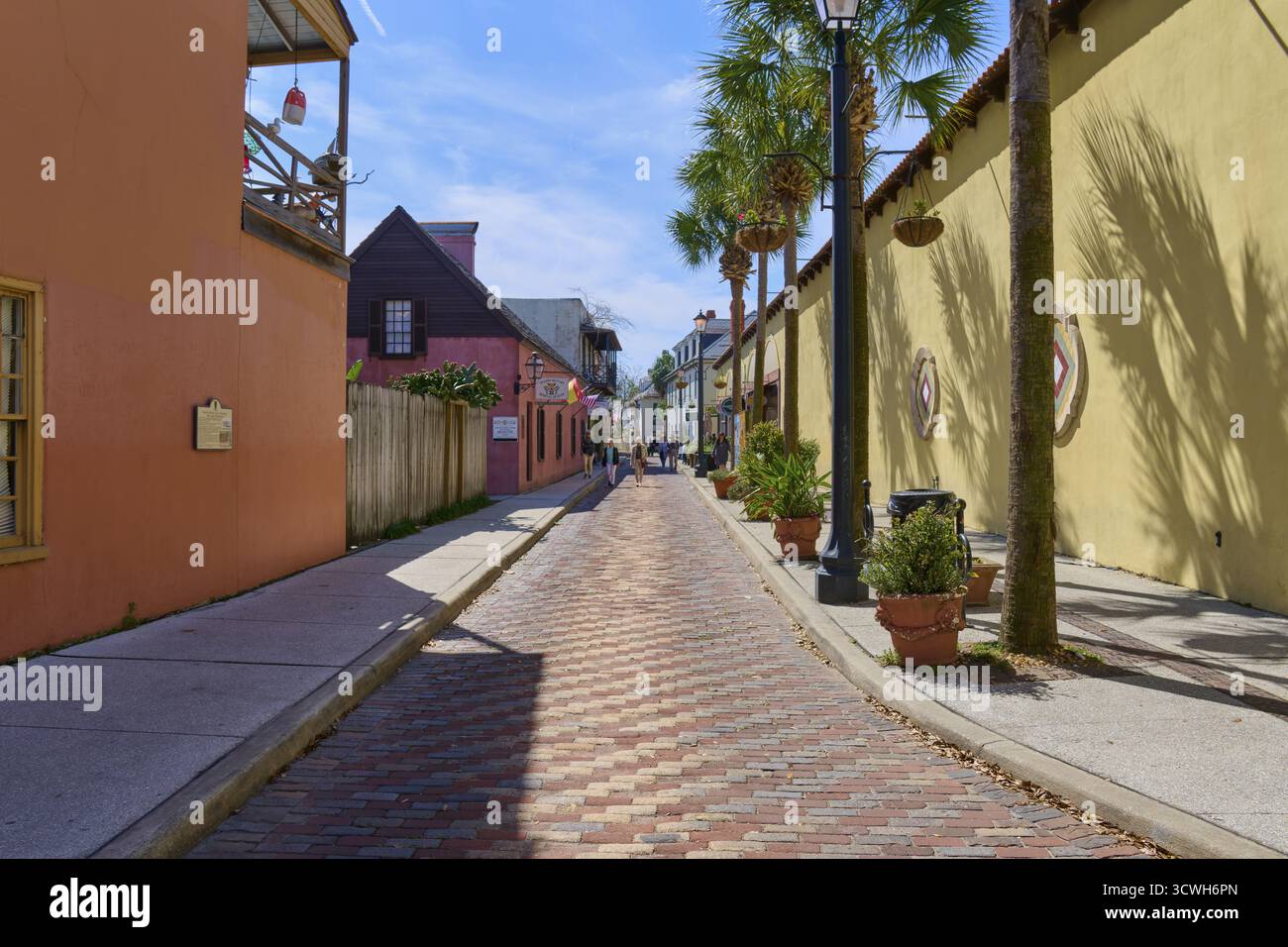 Colourful alley with cobbled alleyway and palm trees in a historic ...