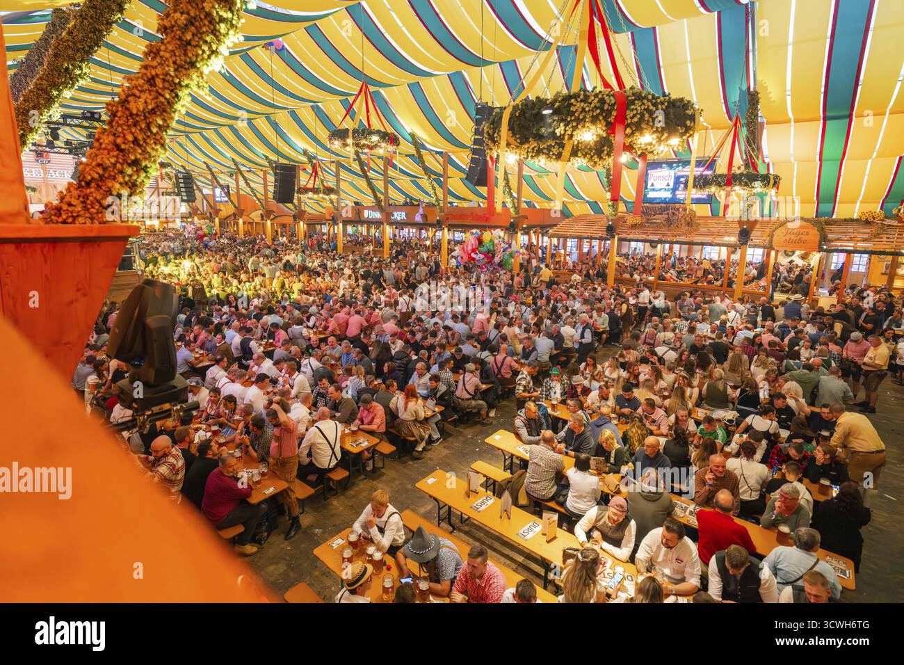Large crowd celebrating in a colourfully decorated marquee, Cannstatter ...