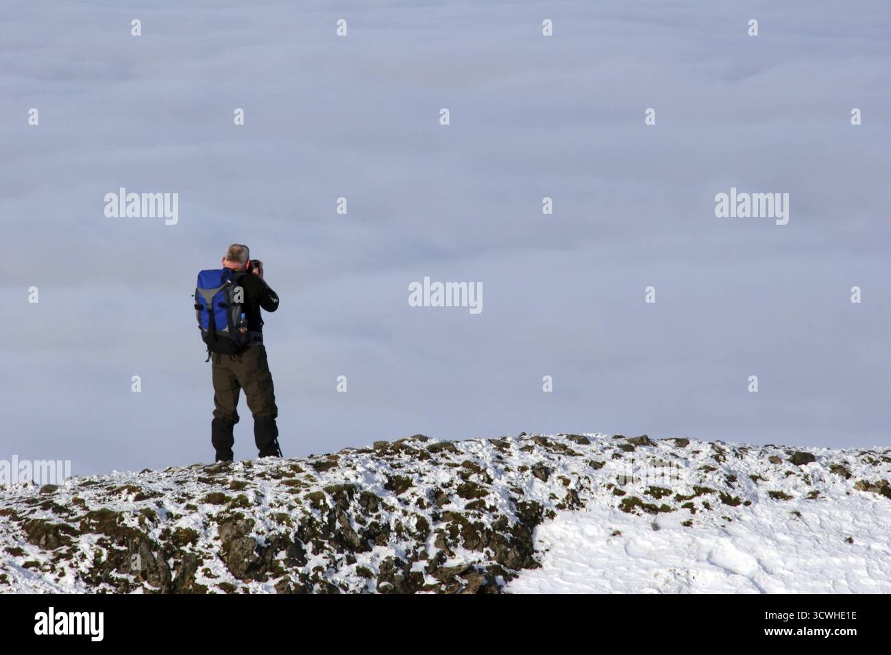 Hillwalker on Ben Challum photographing a cloud inversion. Model ...