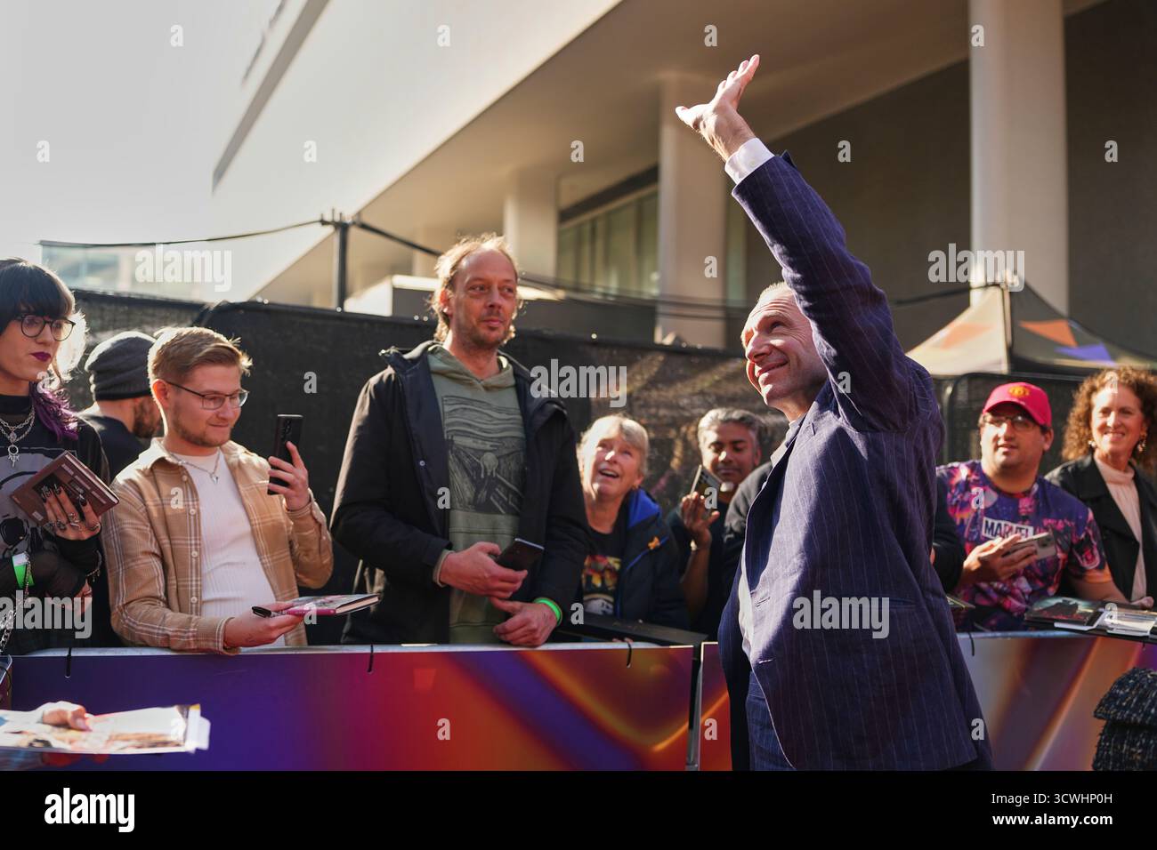 Ralph Fiennes waives to fans upon arrival at the premiere of the film ...