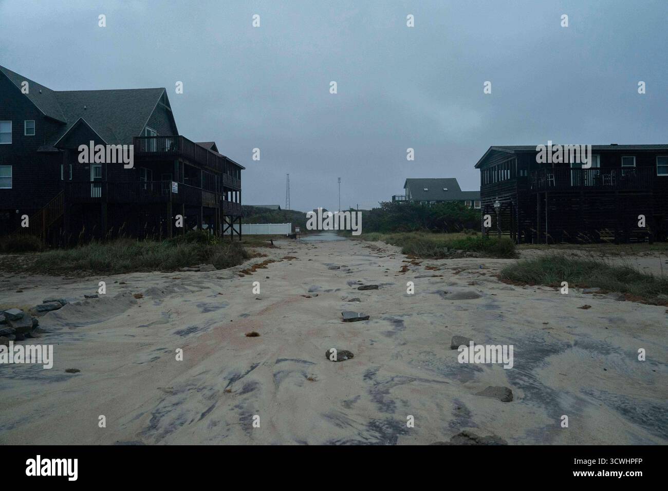 A road covered in sand is seen in the midst of a storm, Sunday, Oct. 12 ...