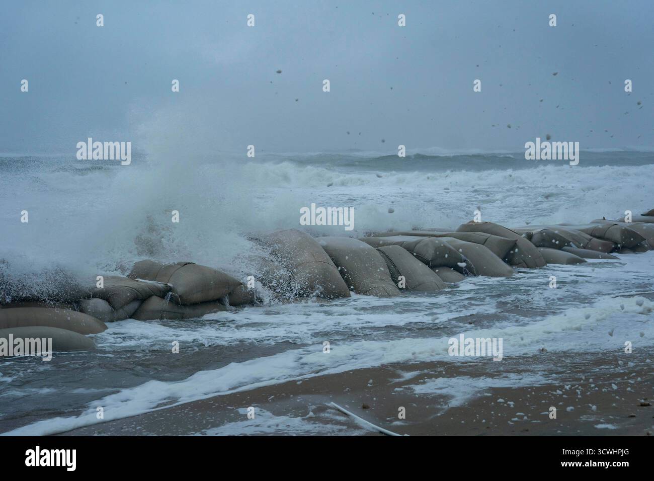 Waves break on top of sand bags in the midst of a storm, Sunday, Oct ...