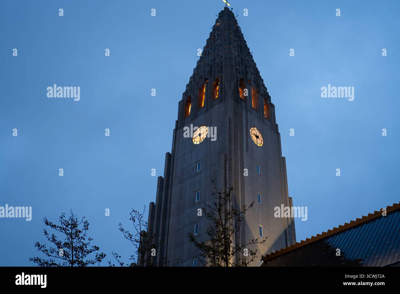 Hallgrimskirkja's illuminated spire and concrete facade stand against a ...