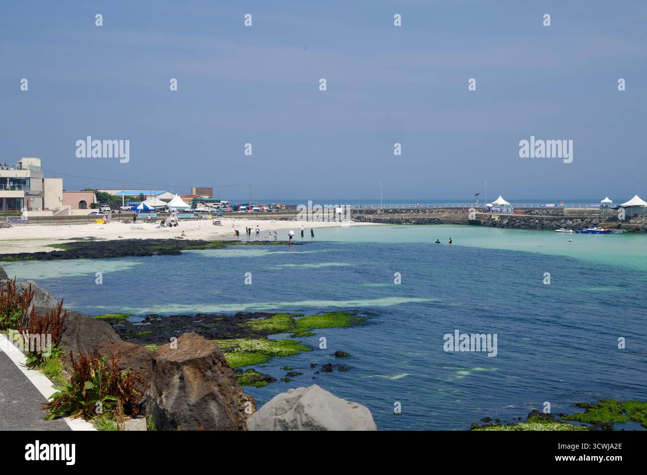 Inside the sheltered cove at Segial Beach, families wade knee‑deep ...