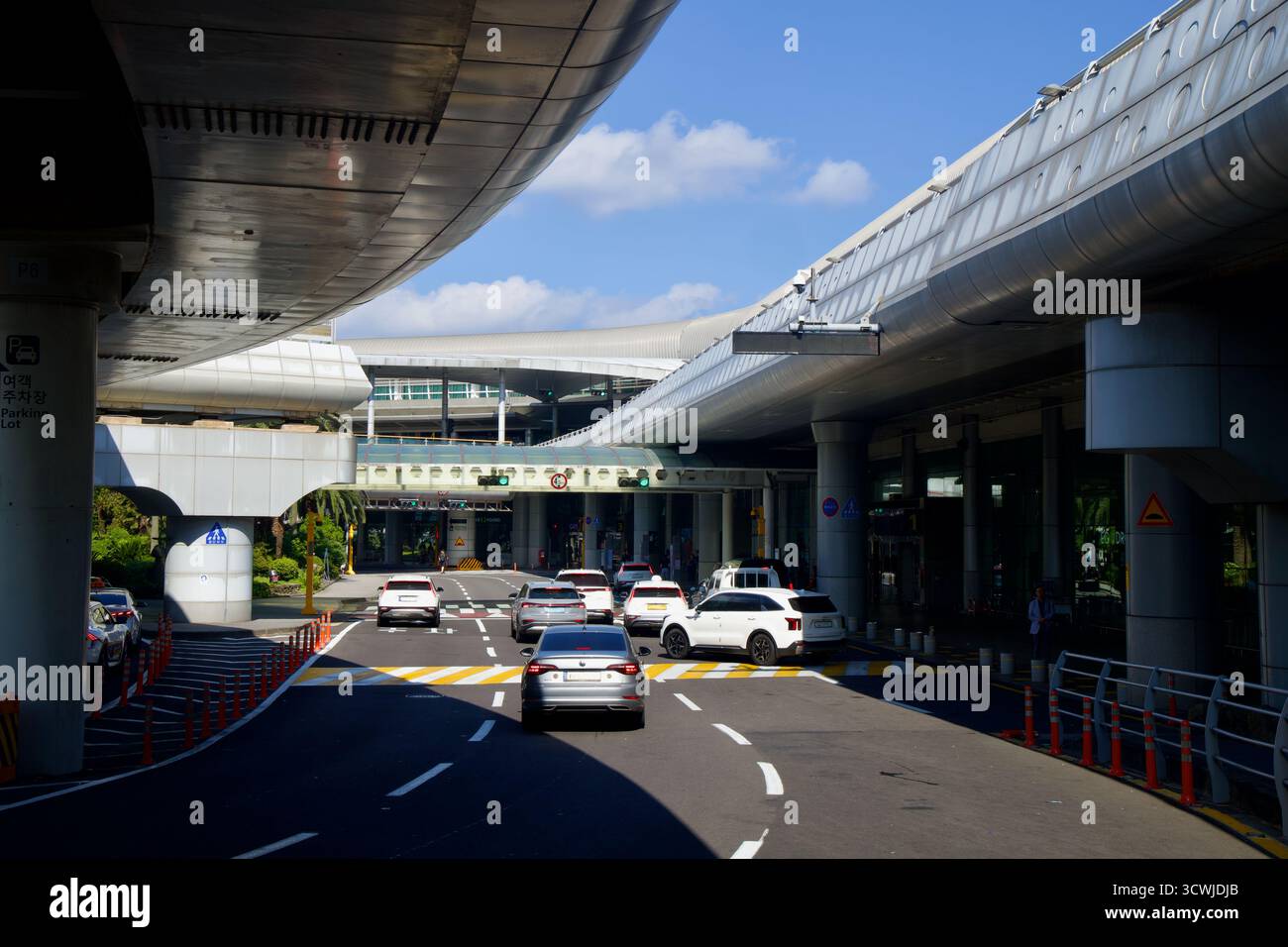 Vehicles queue under curving elevated canopies at the curbside road ...