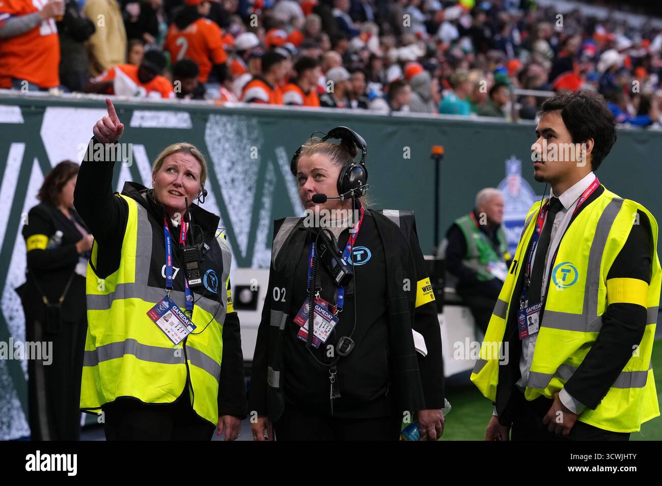 Security workers look into the stands in the second half of an NFL ...