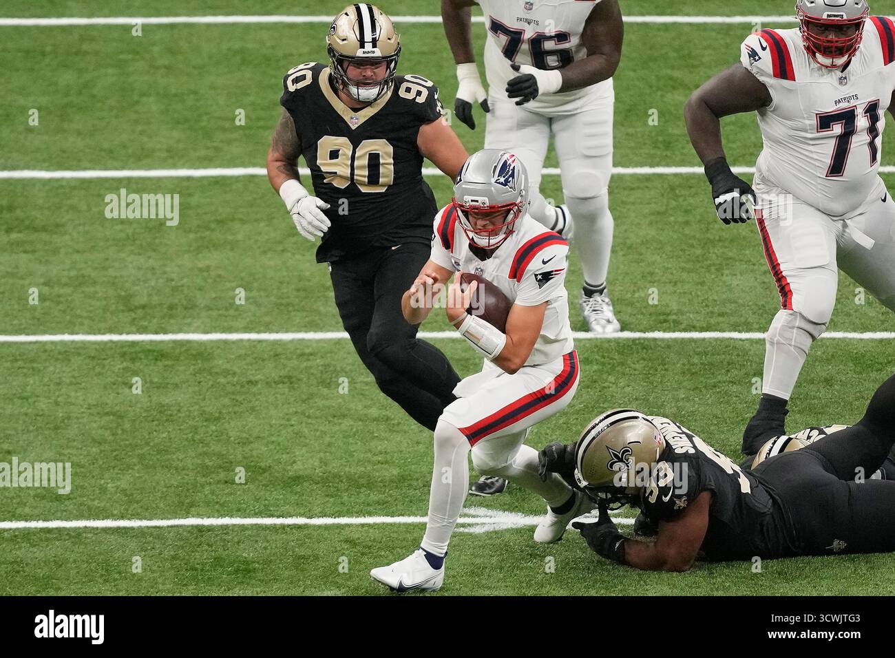 New England Patriots quarterback Drake Maye, center, is tackled by New ...