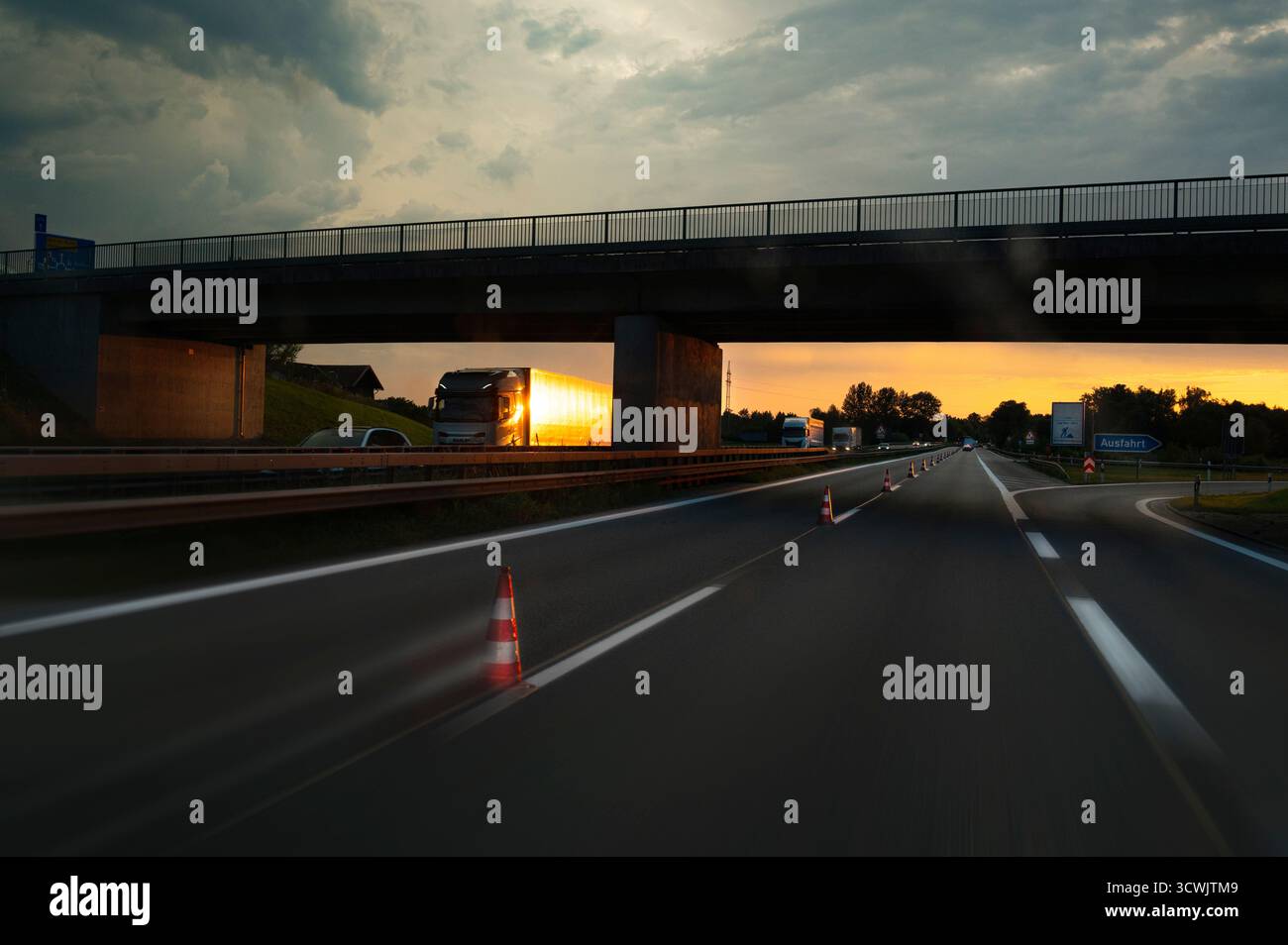 Warning beacons at a motorway construction site are illuminated by car ...