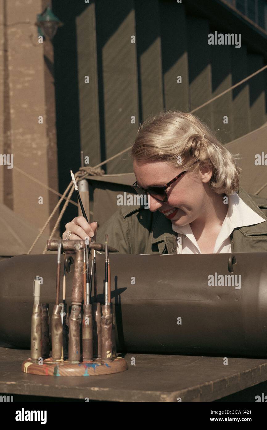 Blonde woman in vintage uniform operating navigation equipment at ...