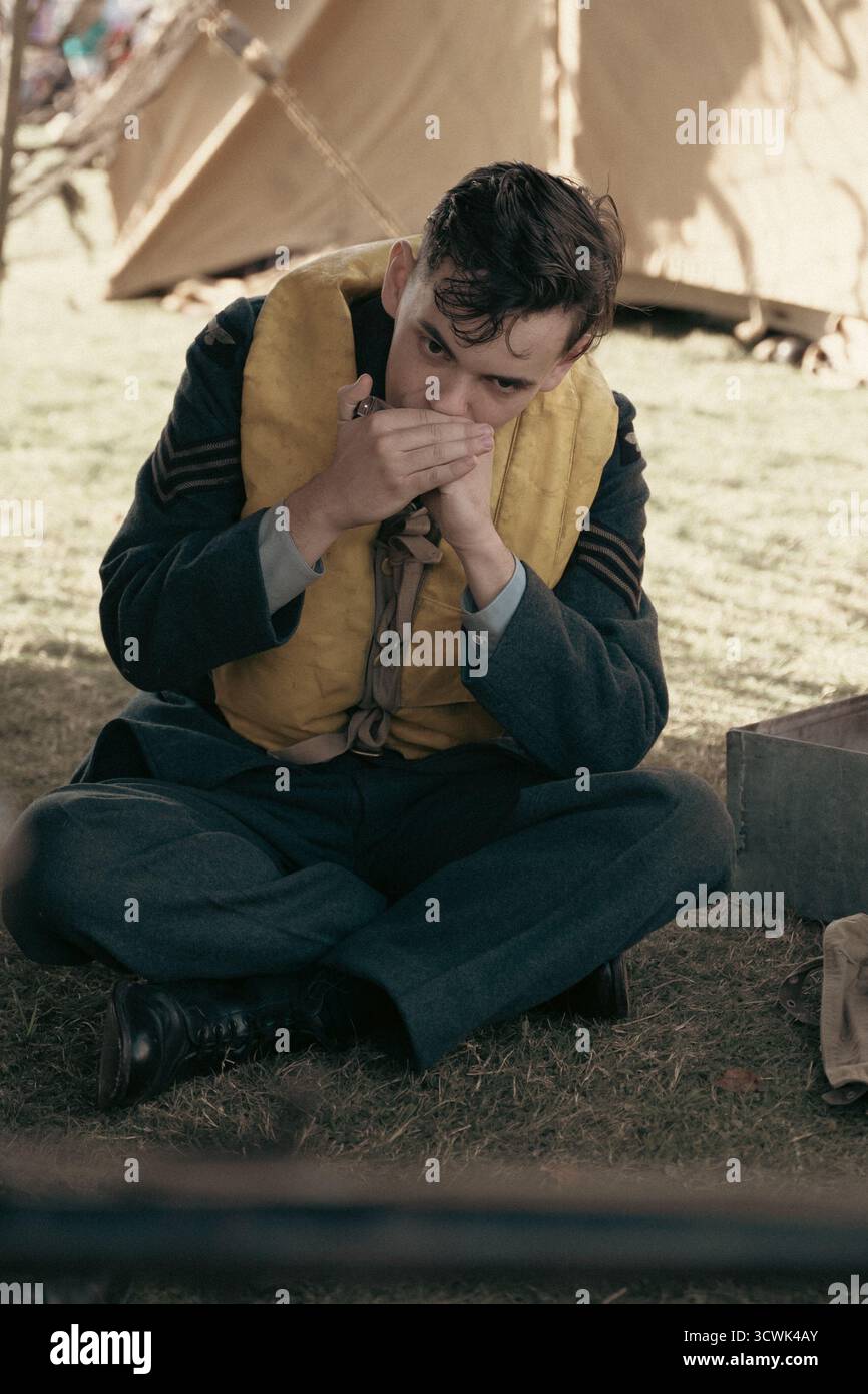 RAF pilot in life jacket sits contemplatively at wartime airfield Stock ...