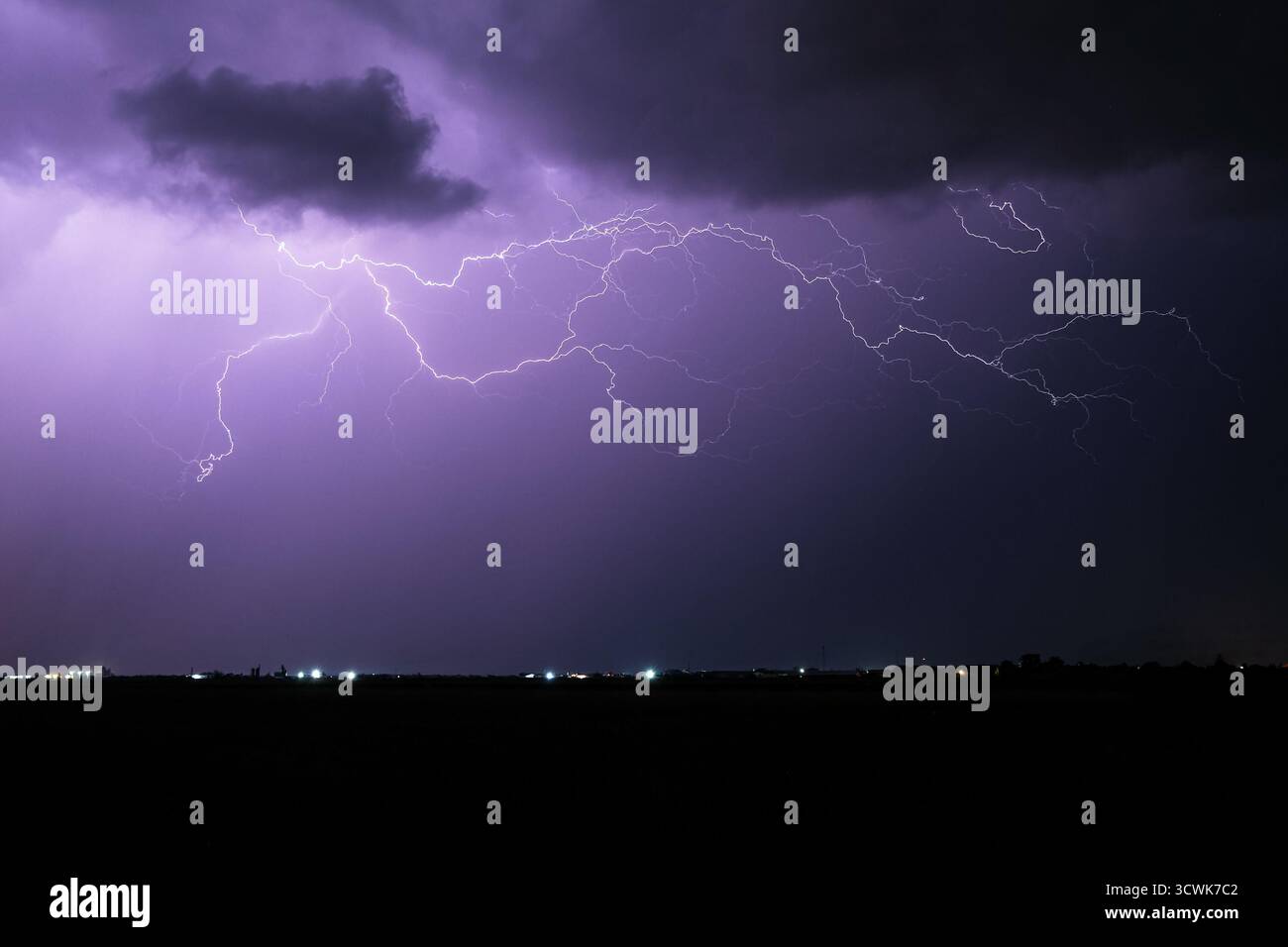 A powerful lightning storm lights up the night sky with bright electric ...