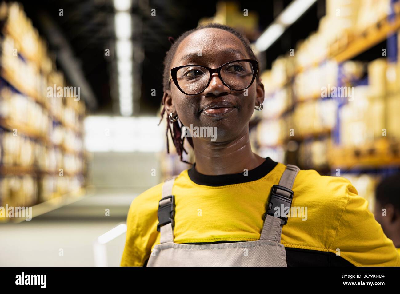 Focused warehouse clerk looking around the storage racks for inventory ...