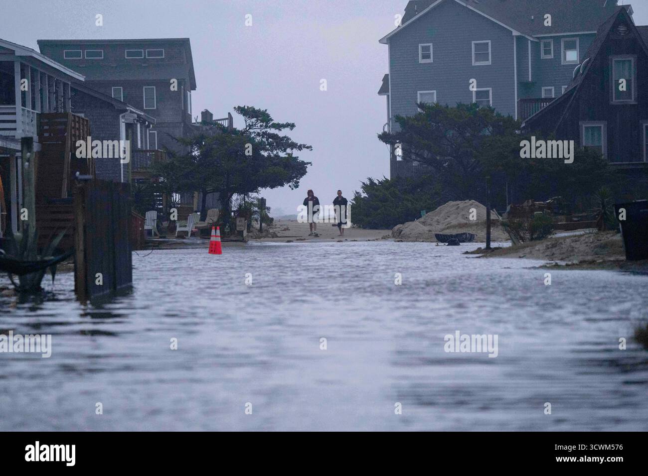 People look out at a flooded road in the midst of a storm, Sunday, Oct ...