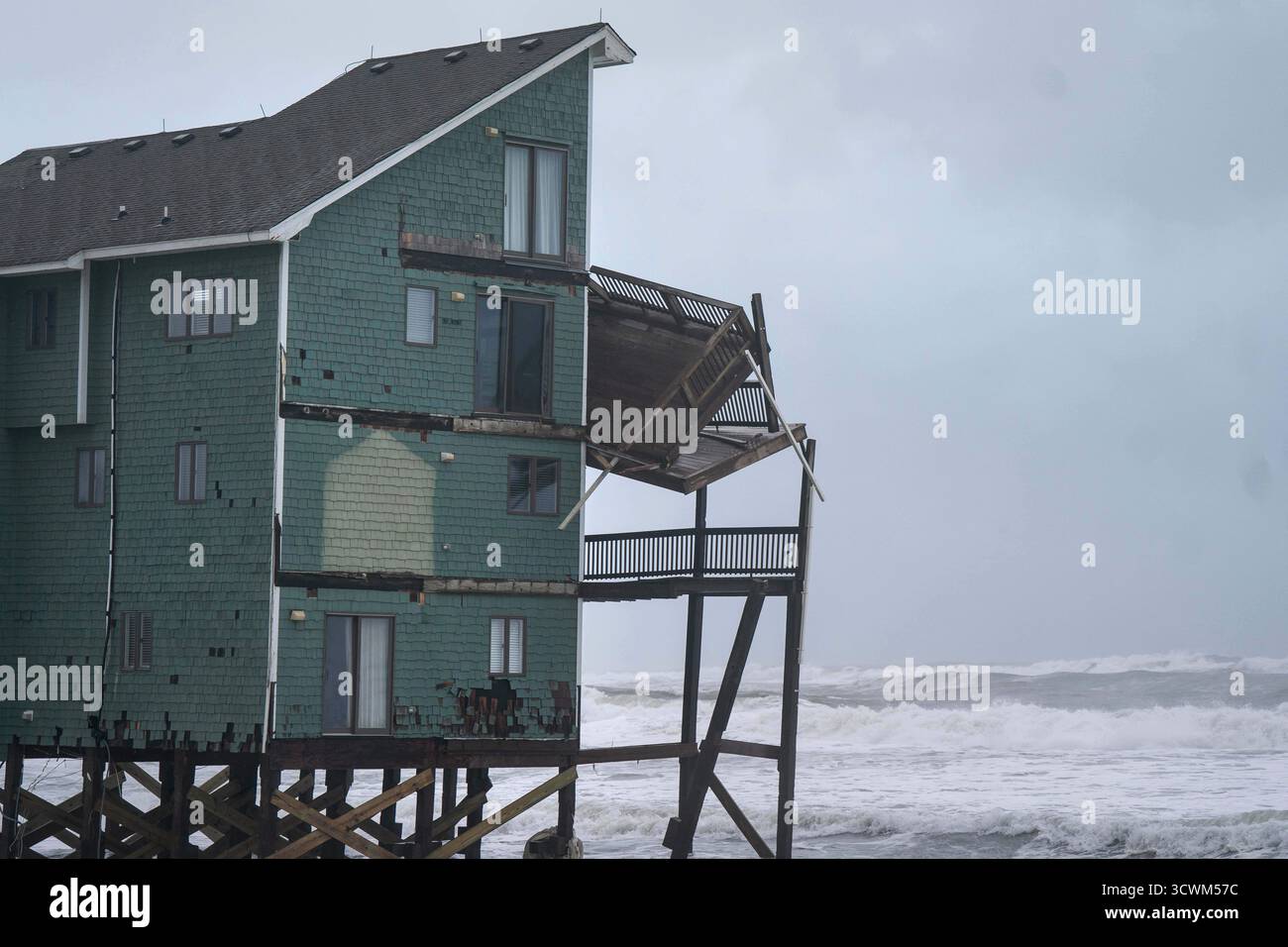 A balcony hangs off a home at risk of collapse in the midst of a storm ...