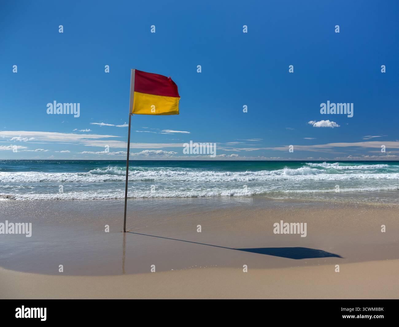 A red and yellow Australian surf lifesaving flag stands firmly planted ...
