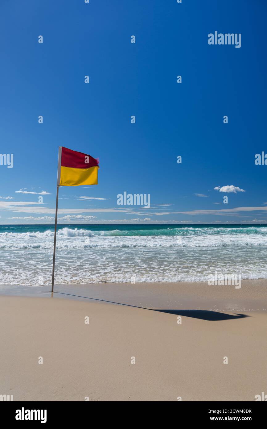 Red and yellow surf lifesaving flag on an Australian beach marks a safe ...