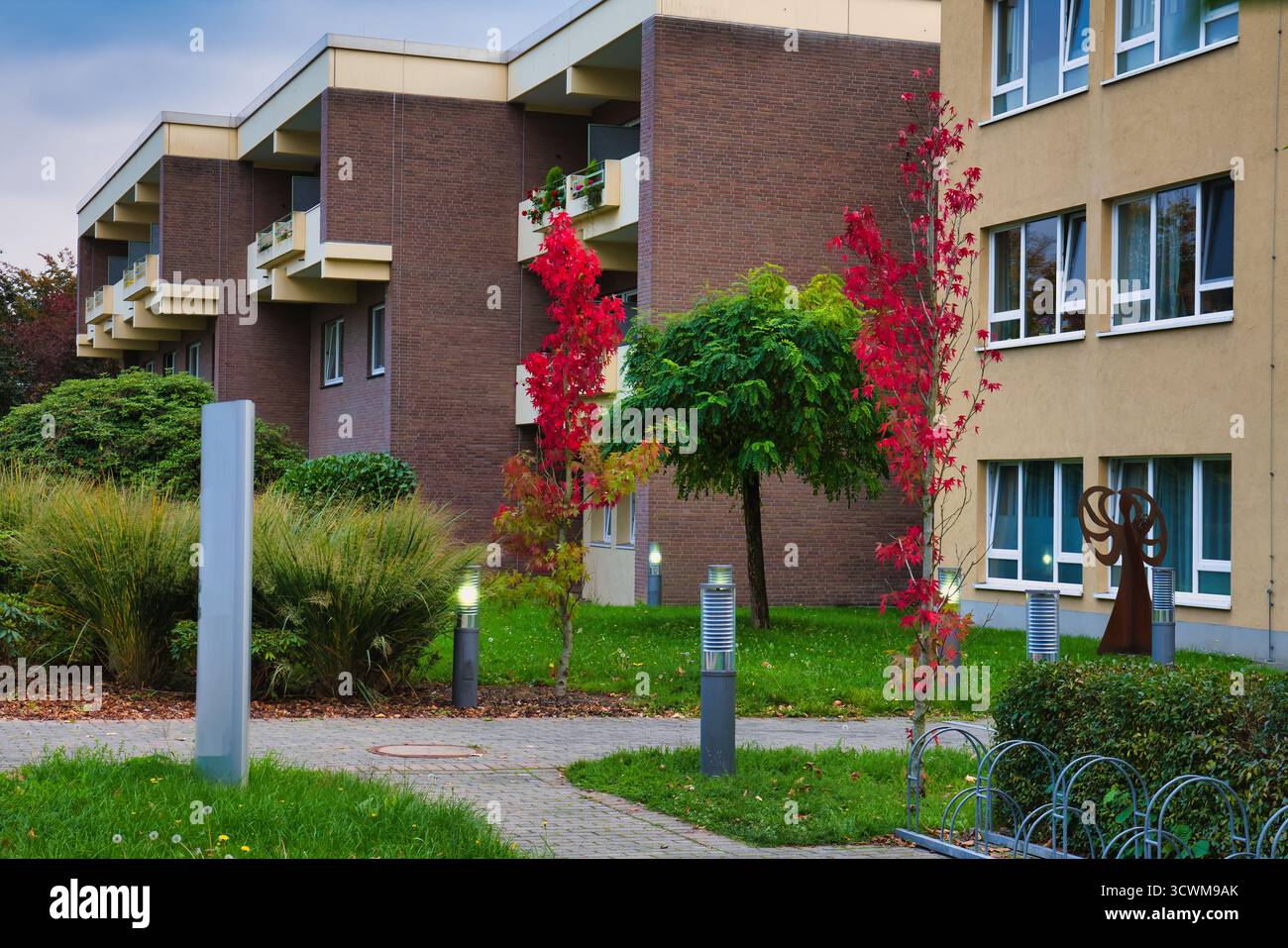 Modern Brick Apartment Building with Balconies and Red Autumn Foliage ...