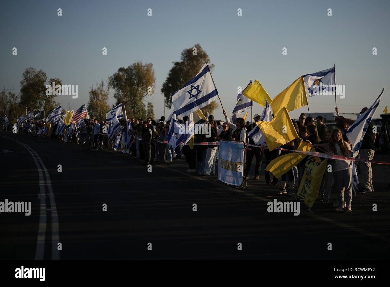 People wave Israeli and U.S. flags as they gather before the release of ...